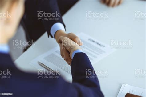 회의 나 협상 클로즈업에서 책상에 앉아있는 동안 비즈니스 사람들은 악수를 현대 사무실에서 알 수없는 사업가의 그룹 팀워크