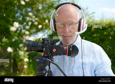A Mature Man With Headphones Using A Camera Dslr Stock Photo Alamy