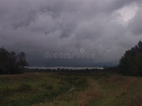 Dense Thunder Clouds Above The Small Narrow River And Forest Stock