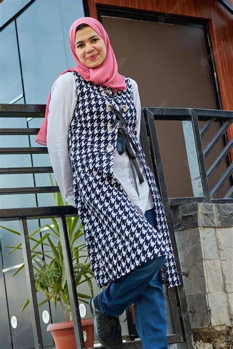 Premium Photo A Woman Wearing A Hijab And A Scarf Stands In Front Of