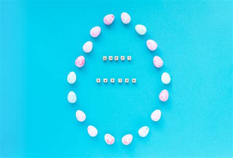작은 색깔의 계란은 파란색 배경의 중앙에 큰 계란의 형태로 배치됩니다 부활절 창조적 인 디자인 인사말 카드 상단 보기 플랫 레이