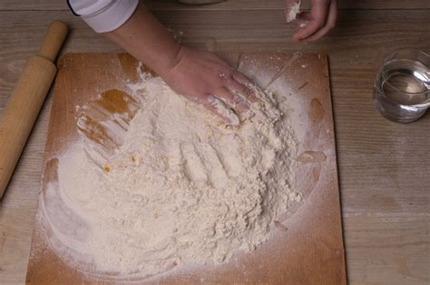한 여성이 반죽을 반죽합니다 반죽을 만들기위한 도구 합판 도마 나무 밀가루 체와 나무 압연 핀 감자 요리에 대한 스톡 사진 및