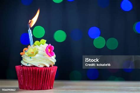 하나의 파란색 촛불과 생일 컵 케이크 사랑 발렌타인 데이를위한 노란색 크림과 마음 컵 케이크 건강에 좋지 않은 음식에 대한 스톡
