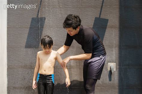 Father And Son Showering At Swimming Pool 이미지 2098334614 게티이미지뱅크