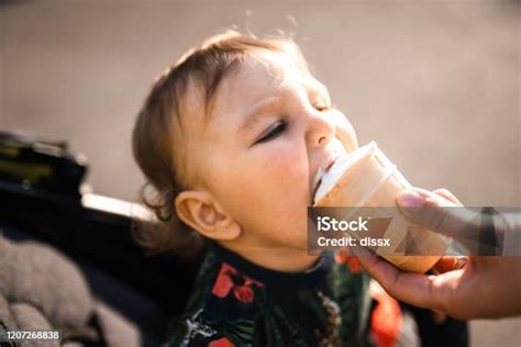 어머니 먹이 아기 아이 소년 아이스크림 젊은 엄마와 그녀의 아기는 흰색 바닐라 크림 디저트를 먹는다 아기 마차 유모차에 앉아