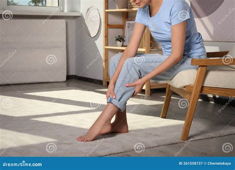 Young Woman Rubbing Sore Leg At Home Closeup Space For Text Stock