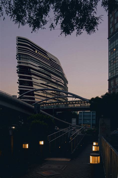 Foto Un Edificio Muy Alto Sentado Junto A Un árbol Imagen Gris Gratis