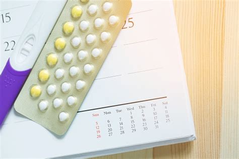 긍정적인 임신 테스트 및 테이블에는 달력의 날짜에 피임 알 약 나무 배경 건강관리와 의술에 대한 스톡 사진 및 기타 이미지