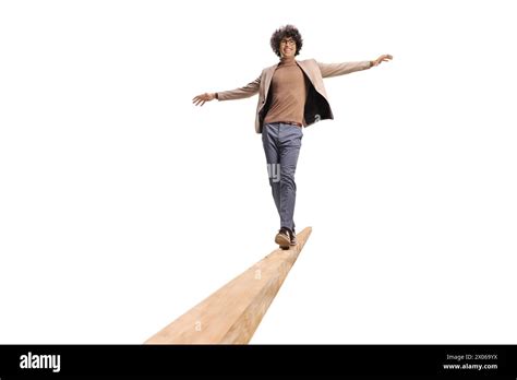 Young Man With Curly Hair Walking On A Wooden Beam And Smiling Isolated On White Background