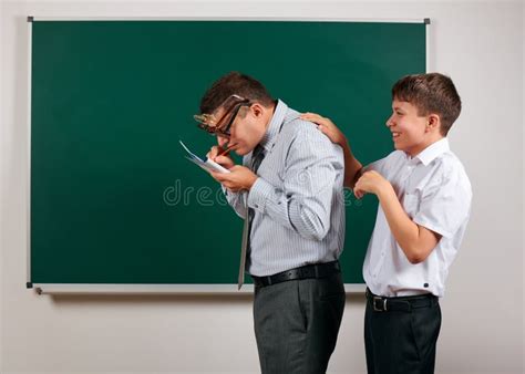 Portrait Of A Teacher Checking Homework Reading School Exercise Books