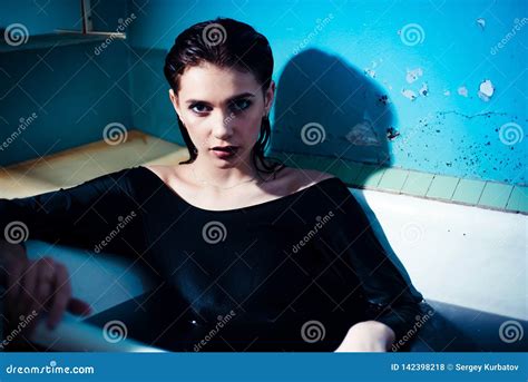 Girl With Bare Shoulders Lying In The Bathroom With Colored Purple