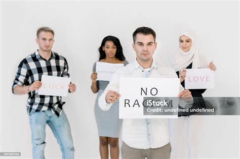 인종차별 기호를 들고 있는 젊은 백인 남성 사회적 슬로건 사랑 행복 흰색 배경에 고립 된 서 있는 세 명의 다민족 친구 활동가 검열에 대한 스톡 사진 및 기타 이미지