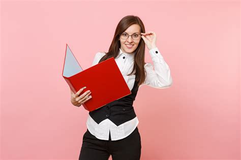젊은 미소 아름 다운 성공적인 비즈니스 여자 안경 들고 핑크 배경에 고립 된 종이 문서에 대 한 빨간색 폴더에 여자 보스입니다