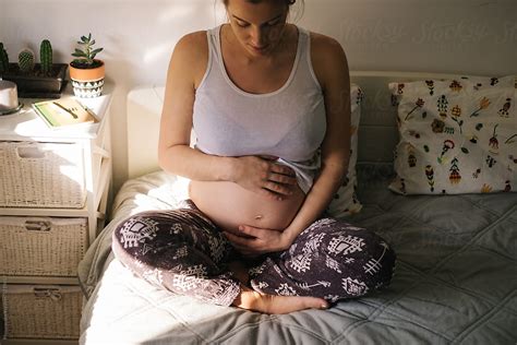 Pregnant Woman Sitting On The Bed By Stocksy Contributor Mosuno