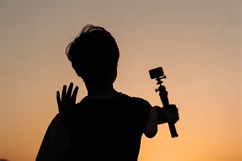 그의 손에 카메라를 들고있는 동안 인도 십대 블로그의 실루엣 소셜 미디어에 대한 십대 블로그 젊은 십대 들고 카메라와 말하기 에