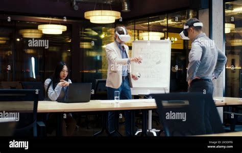 Multi Ethnic Engineers In Vr Headsets Using Laptop And Wireless