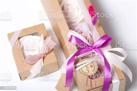 공예 용지 포장에 마시멜로 리본과 말린 꽃으로 장식되어 있습니다 장미의 형태로 제퍼 흰색 배경에 공휴일에 대한 스톡 사진 및
