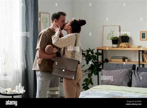 Un jeune couple affectueux partage son baiser le matin tandis qu une femme va partir avec bébé