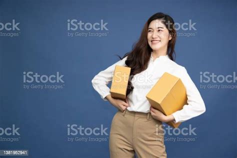딥 블루 배경 택배 및 배송 서비스 개념에 고립 된 패키지 소포 상자를 들고 행복한 아시아 사업가 고객에 대한 스톡 사진 및