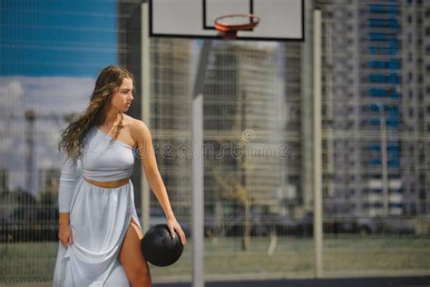 Athletic Woman In White Dress Poses On Basketball Court Glamorous