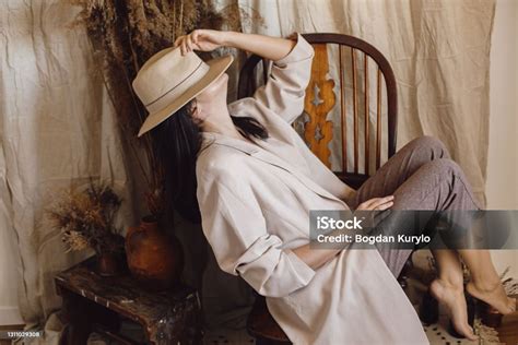 마른 잔디와 보헤미안 방에서 나무 의자에 포즈 정장과 모자에 세련된 유행 여성 갈색에 대한 스톡 사진 및 기타 이미지 갈색 꽃 식물 단순함 Istock