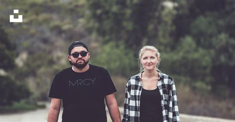 검은 크루넥 티셔츠를 입은 남자가 파란색과 흰색 체크무늬 드레스를 입은 여자 옆에 서 있다 사진 Unsplash의 무료 사람 이미지