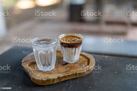 더러운 커피 또는 차가운 신선한 우유 층과 혼합 에스프레소 샷 의 유리 테이블에 나무 트레이에 물과 함께 제공 0명에 대한 스톡