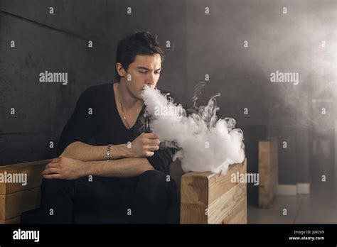 Vaping Man Holding A Mod A Cloud Of Vapor Black Background Smoking
