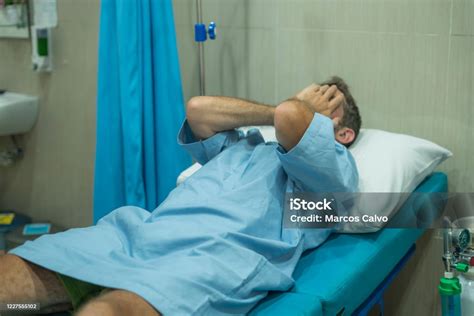 병원방에서 통증에 무서워하고 걱정하는 남자 매력적인 부상당한 남자가 아픈 느낌과 사고 또는 심각한 질병을 겪은 후 스트레스를