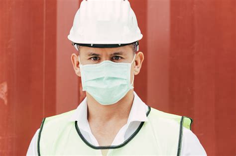 건축 현장에서 카메라를 바라보는 보호얼굴 마스크를 쓰고 있는 백인 엔지니어의 초상화 얼굴 코로나바이러스 전염병을 예방하기 위한 새로운 정상 근무 의료 35 39세에 대한