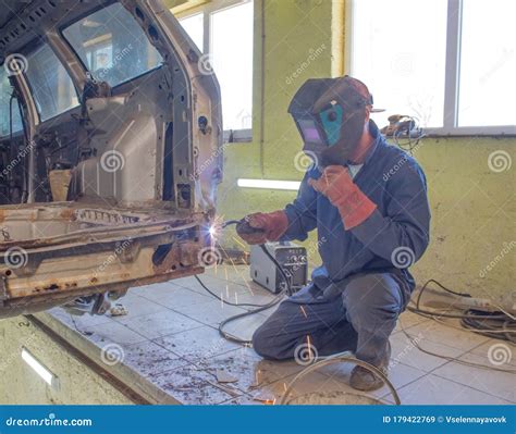 Auto Welder In The Process Of Welding A Car Body In A Workshop Auto