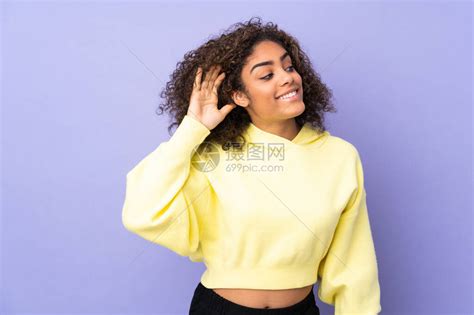 非裔美籍年轻妇女在背景中孤立地听着一些东西高清图片下载 正版图片504371263 摄图网