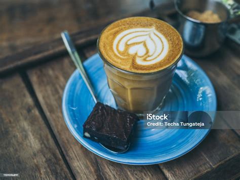 피콜로 라떼 커피 토핑과 작은 유리에 우유에서 꽃 예술 토핑 나무 테이블에 블루 세라믹 접시에 수제 브라우니 케이크 조각 갈색에 대한 스톡 사진 및 기타 이미지 Istock