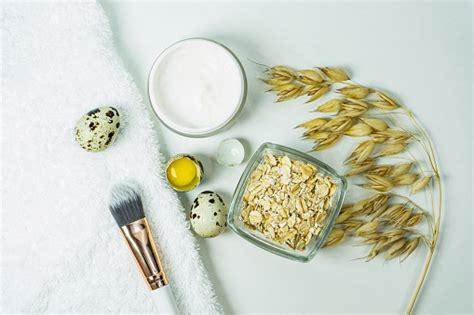 계란을 기본으로 한 천연 화장품의 개념 병의 레이아웃 브러쉬와 생 계란 작은 컵에 오트밀 보습제 스파 개념입니다 가정 생활에
