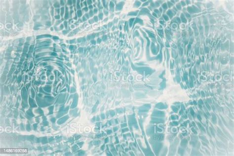 表面に波紋のある青い水ぼかした透明な青色の透明な穏やかな水面テクスチャーと水しぶきと泡の焦点をぼかします輝くパターンテクスチャ背景に水の波