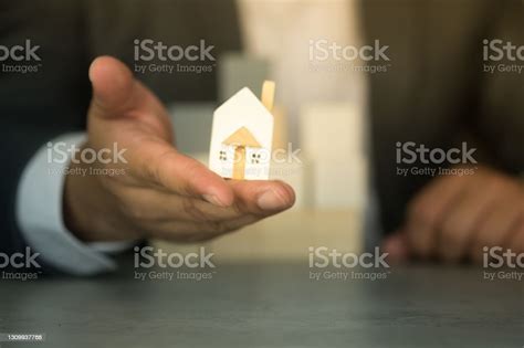 미니 우드 하우스 모델을 들고 정장에 부동산 주택 아파트 및 부동산을 판매하는 개념 개념에 대한 스톡 사진 및 기타 이미지