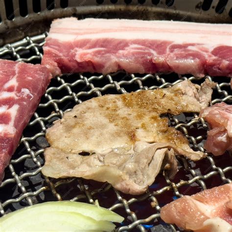 Premium Photo Grilling Pork Belly Meat On A Round Bbq Net In