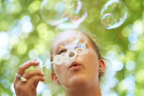 Bubble Blowing Blonde A Young Woman Blowing Bubbles Outside Stock