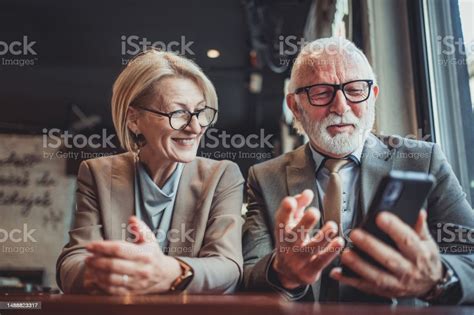 아늑한 카페에 앉아있는 두 명의 성숙한 사업가 남자와 여자는 일상 업무의 스트레스에서 벗어나 편안합니다 2명에 대한 스톡 사진