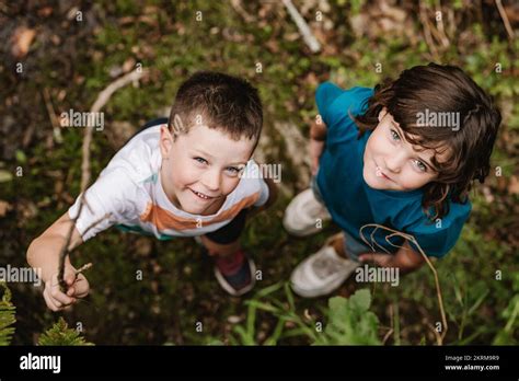 Top View Of Cheerful Boy Smiling And Poking Camera With Stick While