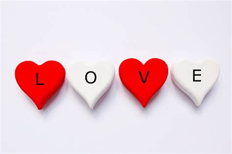 흰색 흰색 나무 배경에 Love로 쓰여진 빨간색과 흰색 나무 수공예 하트 심볼의 최고 보기 발렌타인 데이 테마 2월에 대한 스톡