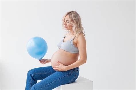 Eine Schöne Junge Schwangere Frau Mit Dickem Bauch In Blauen Jeans Hält