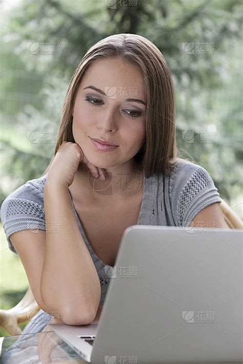 快乐的年轻女子在户外使用笔记本电脑