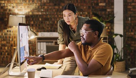 컴퓨터 협업 및 야근을 위해 밤에 사무실에서 직원 팀과 함께 초과 근무를 지시합니다 팀워크 계획 또는 문제 해결 비즈니스 흑인 남성과 함께 일하는 아시아 여성 25 29세에