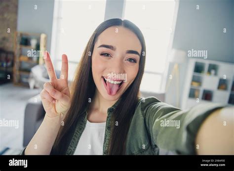 Portrait Of Nice Young Girl Show V Sign Tongue Make Selfie Wear Green