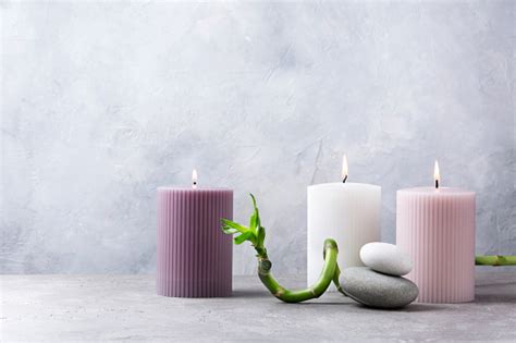 스파와 목욕 컨셉 분홍색과 보라색 색상의 양초 바다 돌과 회색 그런지 배경에 신선한 대나무 공간을 복사합니다 0명에 대한 스톡