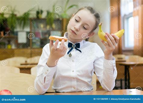 Dziewczyna W Mundurku Szkolnym Wybiera Jedzenie Dla Lunchu Obraz Stock
