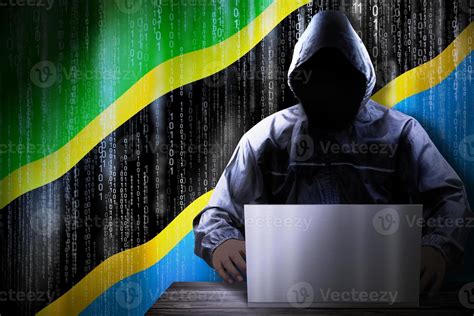 anonymous hooded hacker and flag of tanzania binary code cyber