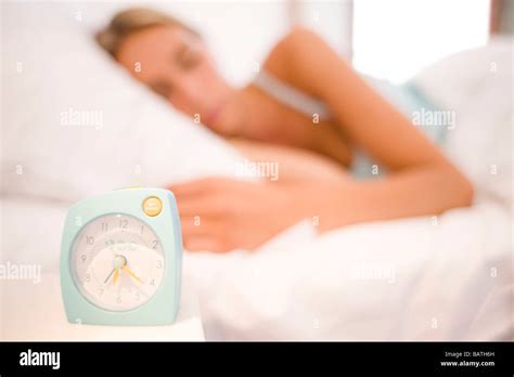 Sleeping Woman Alarm Clock Next To A Woman Asleep In Bed Stock Photo Alamy
