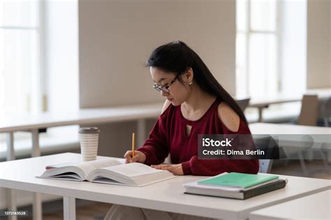 아시아 여자 대학생 학교 책상에 앉아 도서관에서 숙제를하고 교과서에서 메모를 25 29세에 대한 스톡 사진 및 기타 이미지